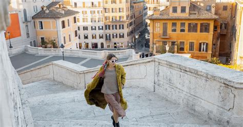 로마의 구시가지를 배경으로 유명한 스페인 계단을 달리는 여자 이탈리아 스타일의 구식 옷을 입은 여자 이탈리아 라이프 스타일의 개념과 유명한 이탈리아 랜드 마크 방문 사진