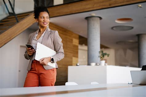 현대 사무실에서 클립보드와 스마트폰을 들고 있는 자신감 넘치는 사업가 40 44세에 대한 스톡 사진 및 기타 이미지 40 44세 Brand Name Smart