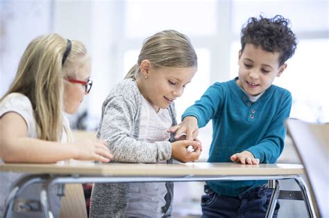 Three Babes In A Classroom Petting A Mouse Stock Photo
