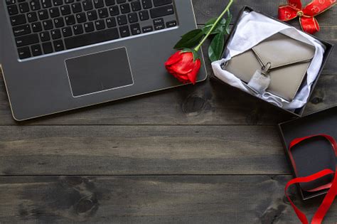 발렌타인 데이 개념에 인터넷 쇼핑을 통해 선물을 구입 상자와 나무 배경에 장미 꽃에서 새 지갑으로 노트북 평면도 평면 복사 공간을 놓으십시오 개념에 대한 스톡 사진 및 기타