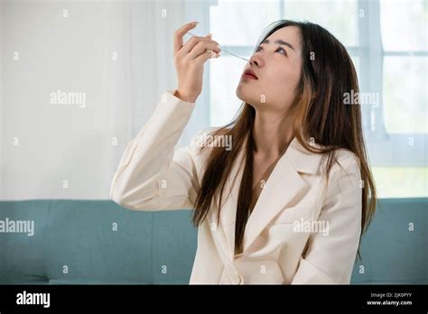 Asian Woman Using Rapid Antigen Test Kit For Selftest Nose Swab Test For Possible Infection
