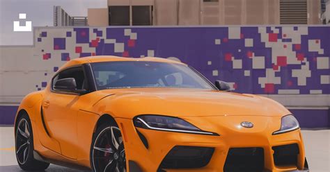 주차장에 주차된 주황색 스포츠카 사진 Unsplash의 무료 자동차 배경 이미지