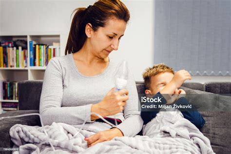 그녀의 작은 아들 소년 아이와 여자 어머니는 침대 약정 치료 천식 폐렴 기관지염 기침 아픈에 집에서 증기 증기 흡입기 분무기 마스크 흡입을 사용하여 그를 확인 2 3 살에