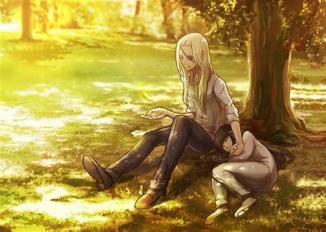 Two People Sitting In The Grass Near A Tree