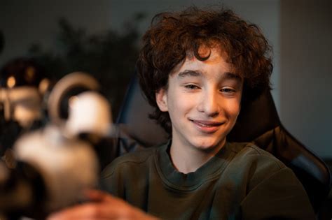 곱슬 머리를 가진 웃는 소년의 초상화는 장난감으로 노는 시간을 보내고 로봇을 조립하고 아이는 전자 제품에 대한 열정을 개발합니다 Stem 주제에 대한 스톡 사진 및 기타