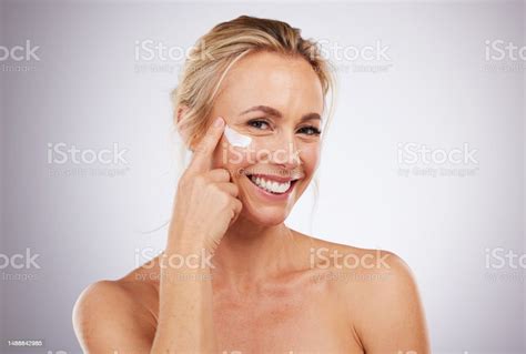 초상화 스킨케어 로션은 노화 방지 뷰티 트리트먼트를 위해 회색 배경에 스튜디오에서 성숙한 여성과 함께한다 얼굴 제품 및 크림은