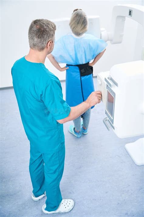 Doctor Performing Knee X Ray Procedure On Caucasian Female Patient