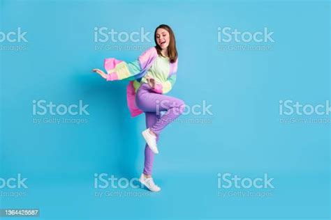 귀여운 달콤한 아가씨의 전체 길이 사진은 한 쪽 다리 고립 된 파란색 배경에 서있는 빈 공간을 찾고 캐주얼 다채로운 의상을 입고 갈색 머리에 대한 스톡 사진 및 기타 이미지