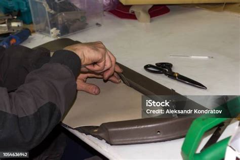 베이 지 색 도어가 위 직장에서 자동차 수리가 게에서 디자인 솔루션을 수행 하는 자동차의 인테리어의 정품 가죽 벗기기 상이 지에 수동 작업을 수행 하는 남성 노동자 가위에