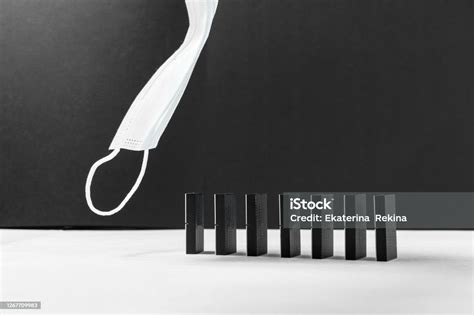 검은 도미노는 비행 의료 마스크와 흰색 배경에 서있다 코로나바이러스 전염병 때문에 사회적 거리의 개념 공간을 복사합니다