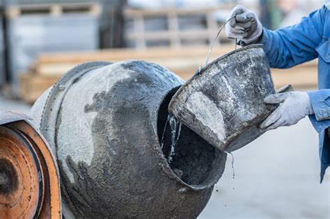 건설 현장에서 박격포 시멘트 믹서에 물 양동이를 넣는 알 수없는 남자의 손에 가까이 시멘트에 대한 스톡 사진 및 기타 이미지