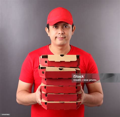 빨간 모자에 잘 생긴 아시아 남자 스튜디오에서 회색 배경에 고립 된 골판지 상자에 음식 주문 이탈리아어 피자를 주는 거리에 대한 스톡 사진 및 기타 이미지 Istock