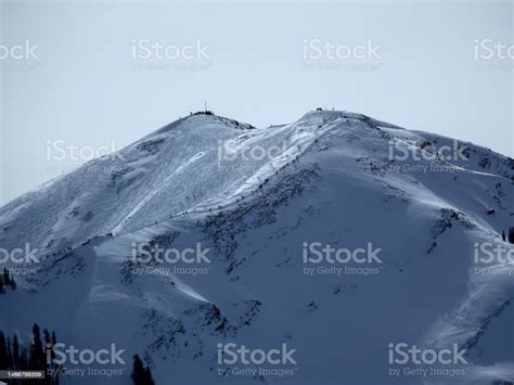 수십 명의 스키어와 스노우 보더가 12392 피트 하이랜드 피크로 하이킹하여 볼을 스키를 타는 망원보기 아스펜 고원에 대한 스톡