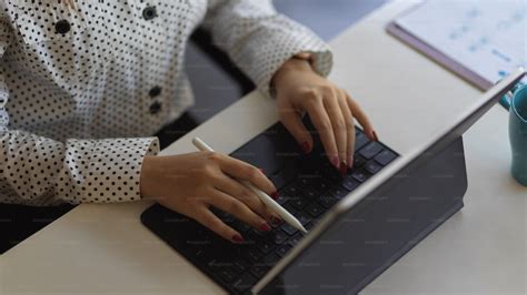 사무실의 흰색 테이블에 태블릿 키보드에 입력하는 여성 손의 상위 뷰 사진 Unsplash의 컴퓨터 이미지