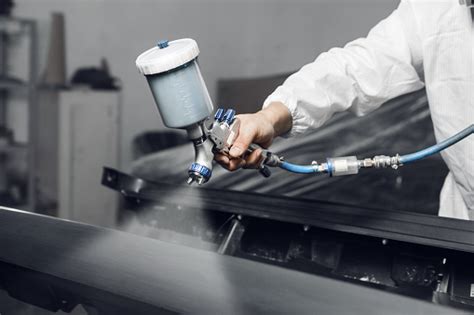 마스크를 쓰고 페인트 챔버에서 자동차의 일부를 그리는 보호 작업복을 입은 자동차 수리공 화가의 장면을 닫습니다 검은색에 대한 스톡 사진 및 기타 이미지 Istock