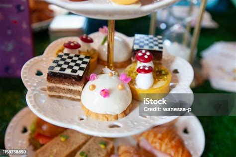 이상한 나라의 앨리스 테마에서 애프터눈 티의 마법과 다채로운 세트 맛있고 맛있는 디저트 짭짤한 맛 빵집 및 페이스트리 이상한 나라의 앨리스에 대한 스톡 사진 및 기타 이미지