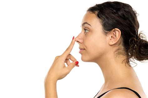 눈을 뜨고 코를 만지는 젊은 여자의 프로필 보기 롤빵에 짙은 곱슬 머리 코 성형 상담을 제안하는 사려 깊은 표현 흰색 배경에