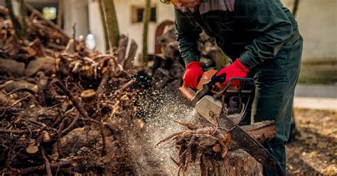 화창한 날 집 뒤뜰에서 전기톱으로 나무 다발을 작업하고 있는 제복과 보호 장치를 입은 벌목꾼의 사진을 닫습니다 사진 Unsplash의 도구 이미지