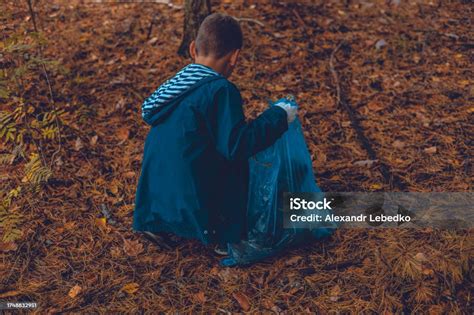 어린이 자원봉사자가 쓰레기 봉투에 플라스틱 쓰레기를 수거하고 있다 어린이 환경 운동가가 플라스틱 쓰레기로부터 숲을 구합니다 쓰레기 환경 문제로 인한 지구 오염 가방에 대한