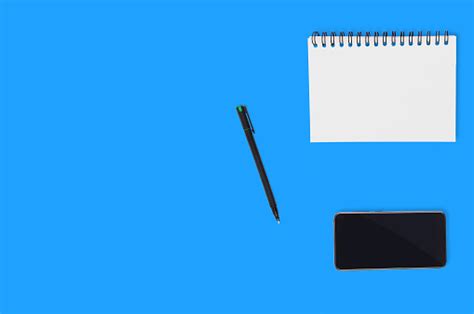 사무실 빈 시트 플라스틱 펜과 파란색 테이블에 밖으로 확산 하는 블랙 스마트폰 종이 메모장을 제공 합니다 최고의 볼 수 있습니다 비즈니스 개념입니다 텍스트에 대 한 공간을