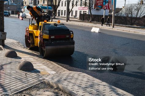 무거운 진동 롤러 압축기를 가진 무거운 아스팔트 도로 롤러는 거리의 도로 건설 현장에서 도로에 새로운 뜨거운 아스팔트를 누릅니다 거리에 대한 스톡 사진 및 기타 이미지