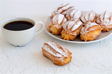 흰색 테이블에 접시에 집에서 만든 바닐라 에클레어 또는 이익 복사 공간을 복사합니다 전통적인 프렌치 맛있는 디저트와 배경에 블랙 커피 한 잔 0명에 대한 스톡 사진 및 기타