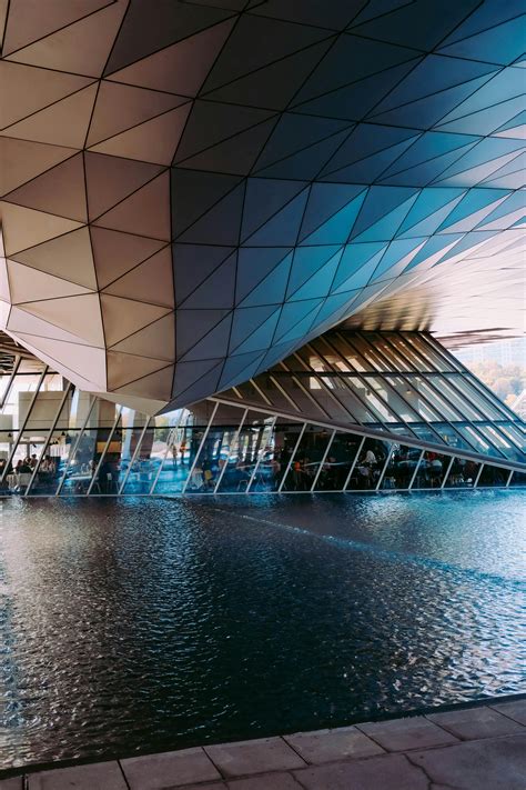 Low Angle Shot Of A Futuristic Building Design With An Outdoor Pond