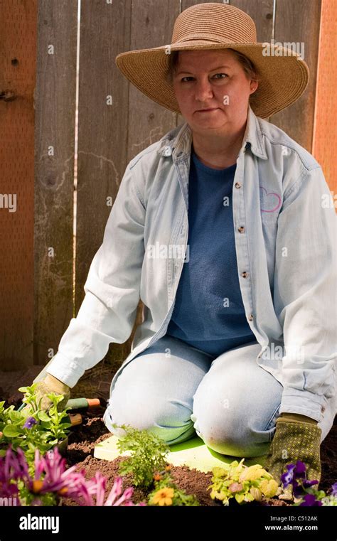 Mature Woman Gardening In Backyard Planting Flowers And Plants Stock