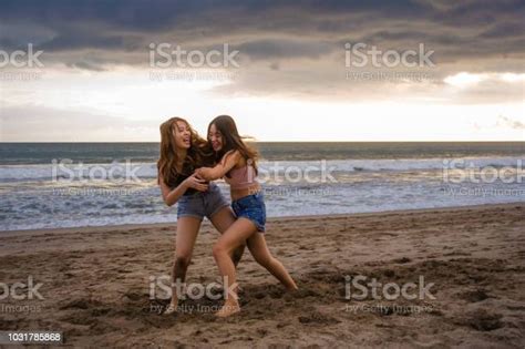 두 행복 하 고 매력적인 젊은 아시아 중국 여자 여자 친구 또는 자매 재미 함께 여행 휴일 아름 다운 빛 여름을 즐기는 선셋 비치에 레슬링 재생 평온한 2명에 대한 스톡