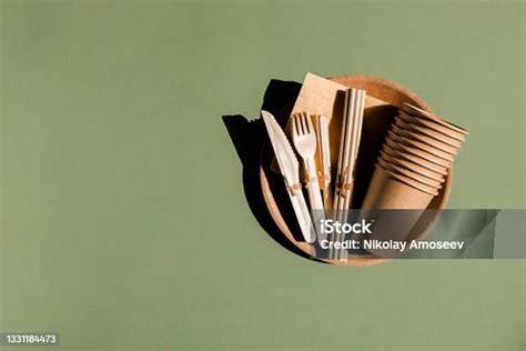 녹색 배경에 가정과 피크닉을위한 에코 친화적 인 식기 세트 플라스틱이 없습니다 제로 폐기물 개념 일회용 종이 식기 컵 접시 나무 포크 칼 숟가락 및 대나무 빨대 0에 대한