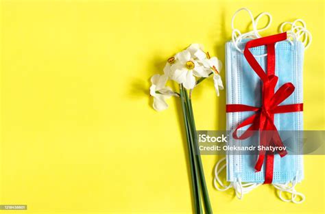 꽃과 노란색 배경에 의료 마스크 코로나 바이러스 보호 바이러스와 싸우는 선물 꽃 배경입니다 0명에 대한 스톡 사진 및 기타 이미지 Istock