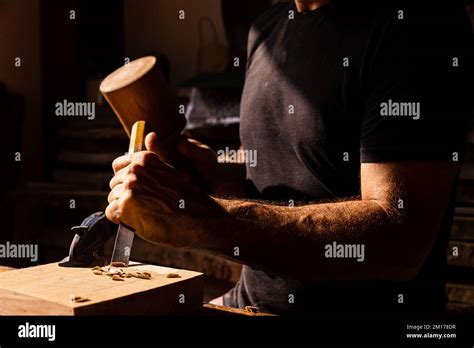 A Close Up Of Man S Hands Using A Chisel And A Mallet On A Piece Of Wood Concept Of Crafts