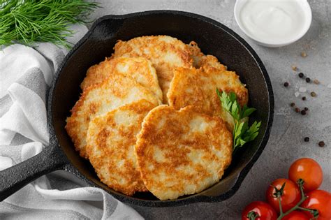감자 팬케이크 Latkes 또는 Draniki는 회색 콘크리트 배경에 주철 팬에 신선한 허브와 사워 크림을 곁들입니다 평면도 복사 공간 0명에 대한 스톡 사진 및 기타