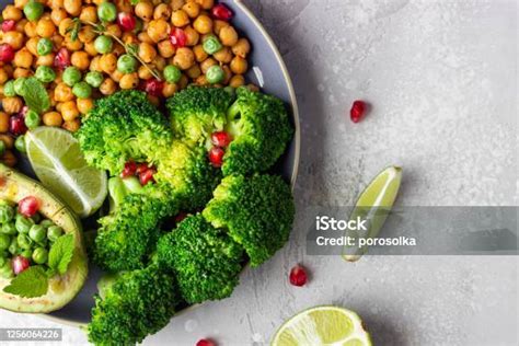 브로콜리 구운 병아리콩 아보카도 녹색 완두콩 석류 씨앗 라임 및 민트의 건강한 야채 점심 비건 음식 깨끗한 식사 또는 다이어트