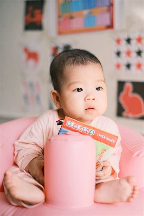 실내에서 컬러풀한 책을 읽는 사랑스러운 아기 · 무료 스톡 사진