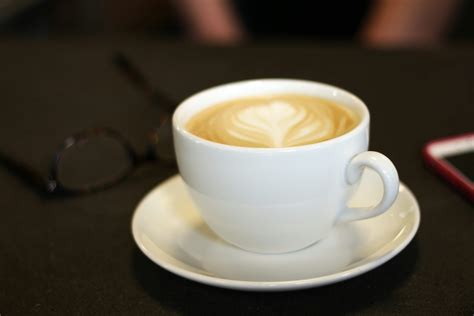 흰색 세라믹 접시에 갈색과 흰색 라떼로 채워진 흰색 세라믹 컵 사진 Unsplash의 무료 오로라 이미지