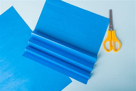 Diy와 아이의 창의력 종이 접기의 개념 단계별 지시 종이 눈송이를 만드는 방법 2단계는 아코디언처럼 종이를 접습니다 어린이 새해 공예 Diy에 대한 스톡 사진 및 기타