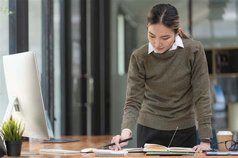 사무실에서 계산기와 데스크톱 컴퓨터를 사용하여 서 있는 아시아계 여성 사업가 30 34세에 대한 스톡 사진 및 기타 이미지 30 34세 검정 머리 계산기 Istock