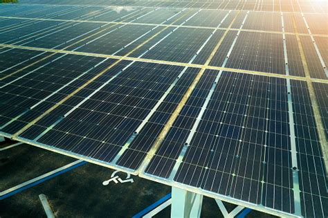 깨끗한 전기의 효과적인 생성을 위해 주차 된 자동차를위한 주차장 위에 그늘 지붕으로 설치된 태양 전지 패널의 조감도 도시 인프라에 통합 된 태양 광 기술 주차장에 대한 스톡