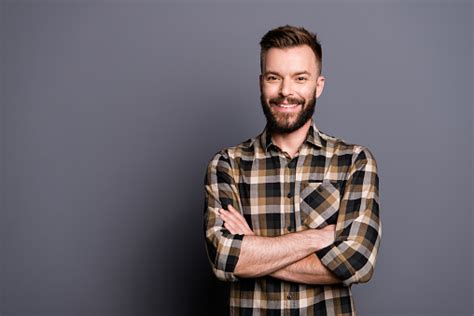 잘 생기고 매력적인 젊은 미소 Brunet 남성 캐주얼 접힌 손을 입고 수염 회색 배경 위에 절연 남자에 대한 스톡 사진 및