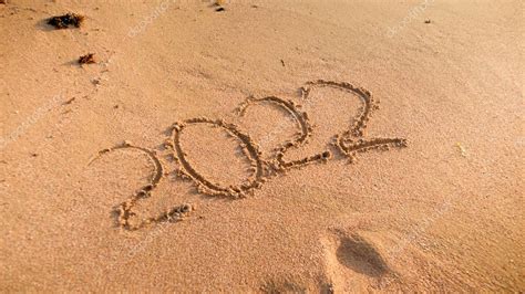 Foto de primer plano de números escritos en arena mojada en la playa del océano Concepto