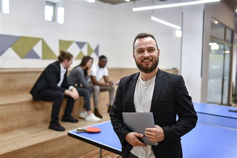 탁구장에서 학생들과 시간을 보내면서 자신감을 보여주는 미소 짓는 대학 교사 가리키기에 대한 스톡 사진 및 기타 이미지 가리키기 공부 교수 Istock
