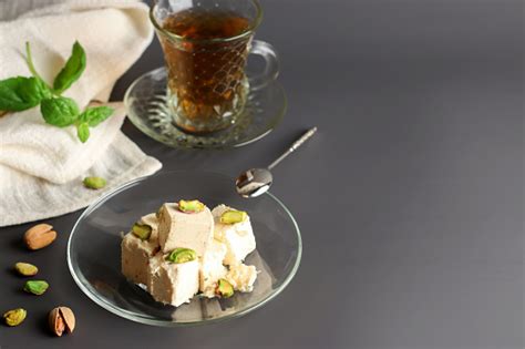 어두운 배경에 유리 접시에 피스타치오를 곁들인 할바 터키어 아랍 유대인 국가 과자 천연 비건 제품 전통적인 동양 디저트 Chekme 공간을 복사합니다 0명에 대한 스톡 사진