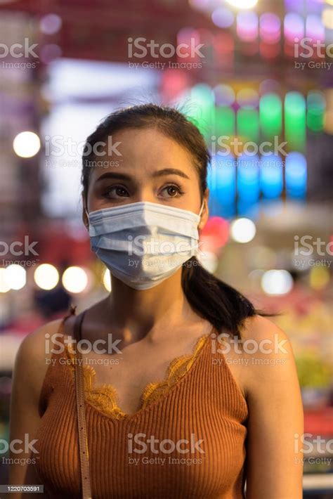 밤에 차이나 타운에서 코로나 바이러스 발병으로부터 보호하기 위해 마스크로 생각하는 젊은 아시아 관광 여성 25 29세에 대한 스톡 사진 및 기타 이미지 Istock
