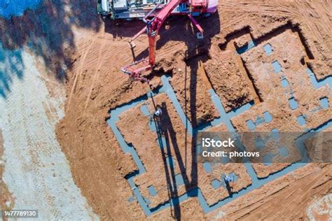 집을 짓는 과정에서 콘크리트 펌프를 사용하여 콘크리트 스트립 기초를 부어 시멘트 콘크리트를 스트립으로 향하게 합니다 Charitable Foundation에 대한 스톡 사진