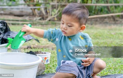 어린 아이는 심기 위해 식물을 준비하기 위해 화분에 흙을 삽질합니다 어머니의 작은 도우미에게 심기 위해 흙을 파는 유아 원예 가정 원예에서 취미 여가 활동 개념 2 3 살에