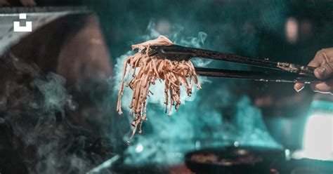 구운 음식이 담긴 흰색 도자기 접시를 들고 있는 사람 앞에서 구운 음식이 담긴 검은색 끈 팬티를 들고 있는 사람 사진