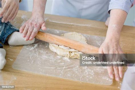 시트 반죽 여성의 손은 롤링 핀을 들고 밀가루를 가루 롤링 핀으로 반죽을 굽는 손 부엌에서 베이킹 직장에서 요리사 부엌에서 여자 테이블에 아기의 작은 발 가정 생활에 대한