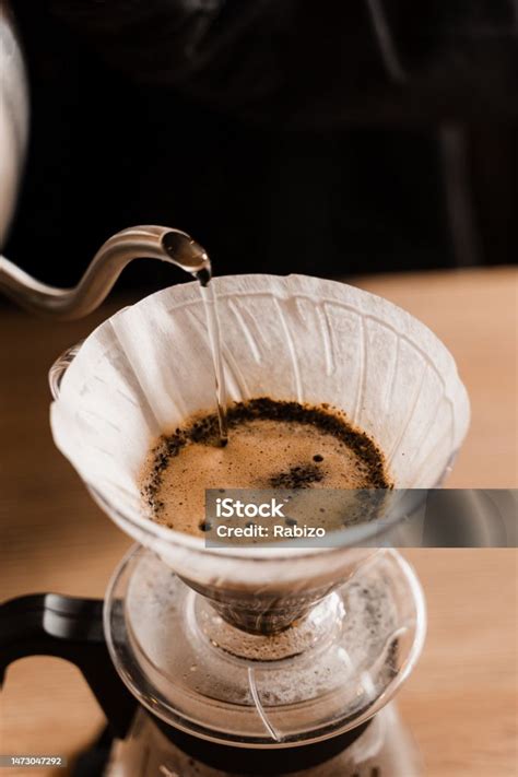 깔때기에 분쇄 커피가 있는 필터를 클로즈업하여 초점을 맞춥니다 드립 필터 커피 추출 필터에 포함된 볶은 커피 원두와 분쇄 커피 원두 위에 물을 붓는 다른 방법을 붓습니다