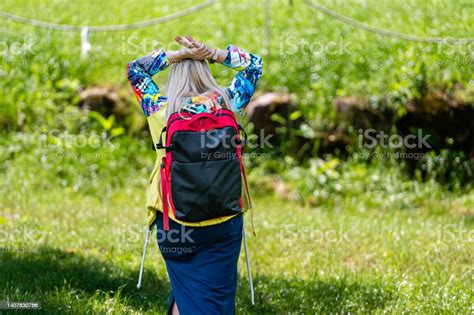 화창한 날에 공원에 배낭이있는 밝은 옷을 입은 금발 중년 여성 뒷모습 50 59세에 대한 스톡 사진 및 기타 이미지 50 59세 가방 걷기 Istock